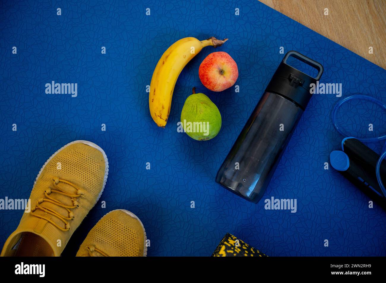 A medley of tropical fruits and a resistance band on the workout mat ...