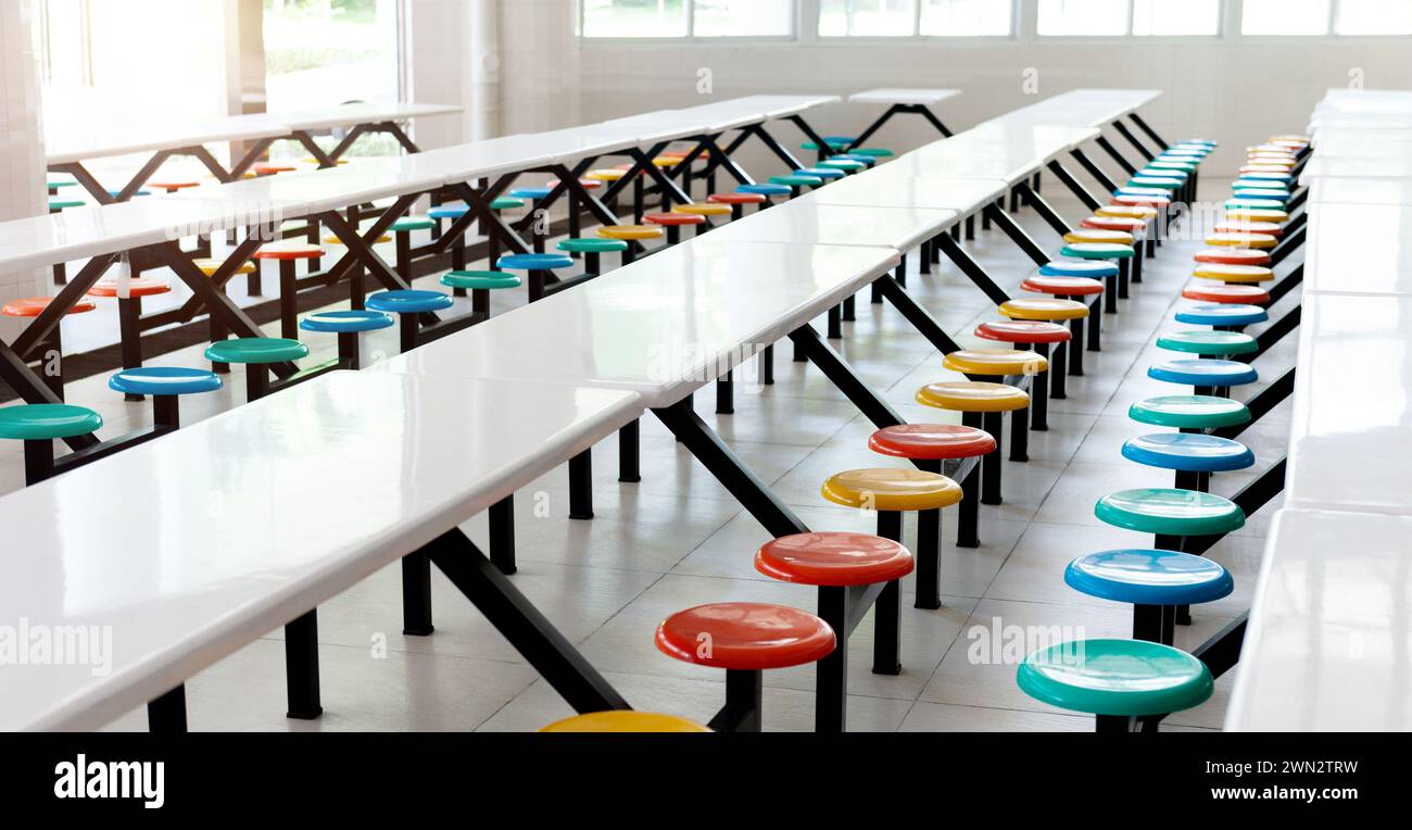 School cafeteria with white tables and colorful seats Stock Photo - Alamy