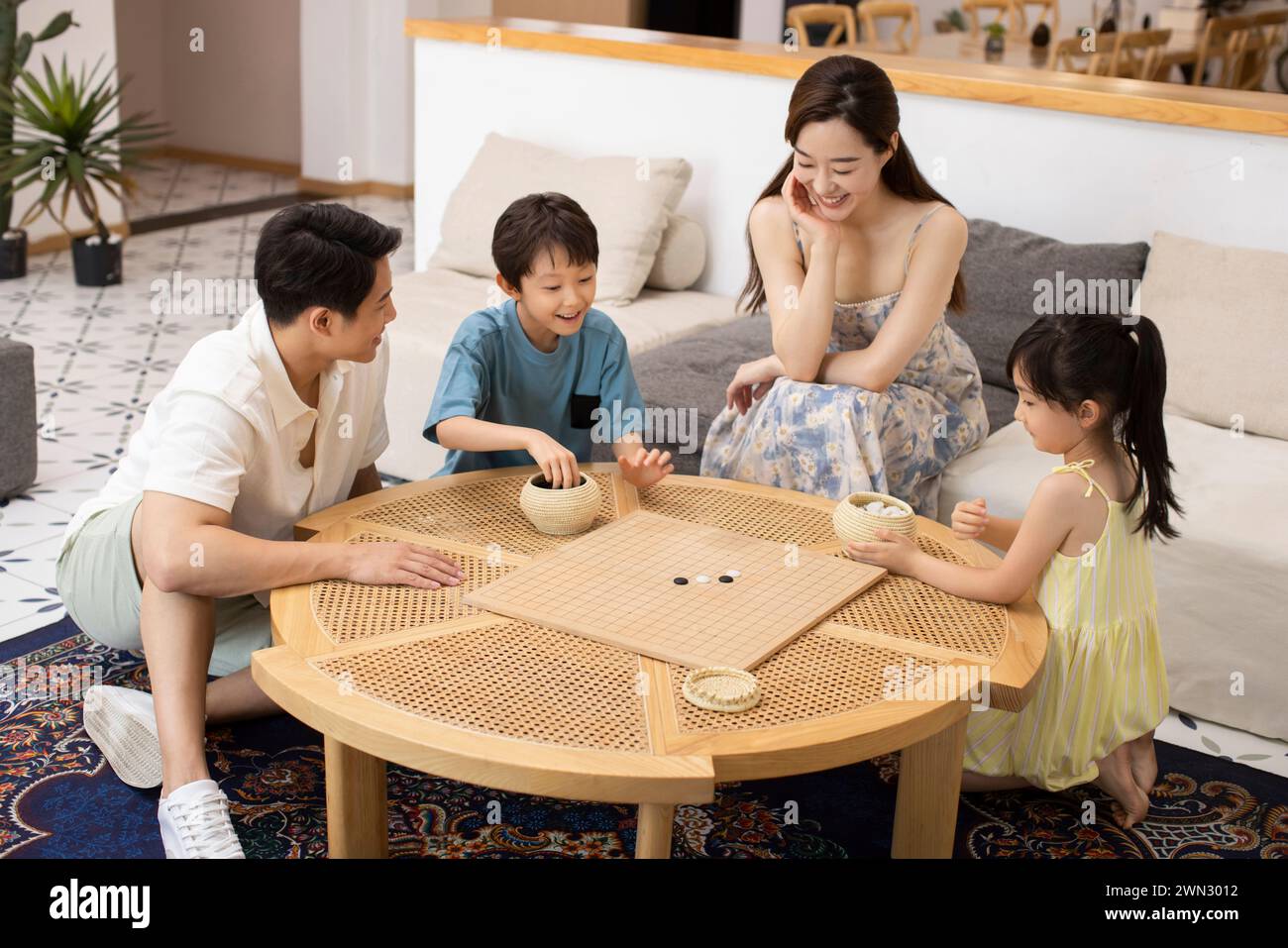 Happy family playing the game of go Stock Photo - Alamy