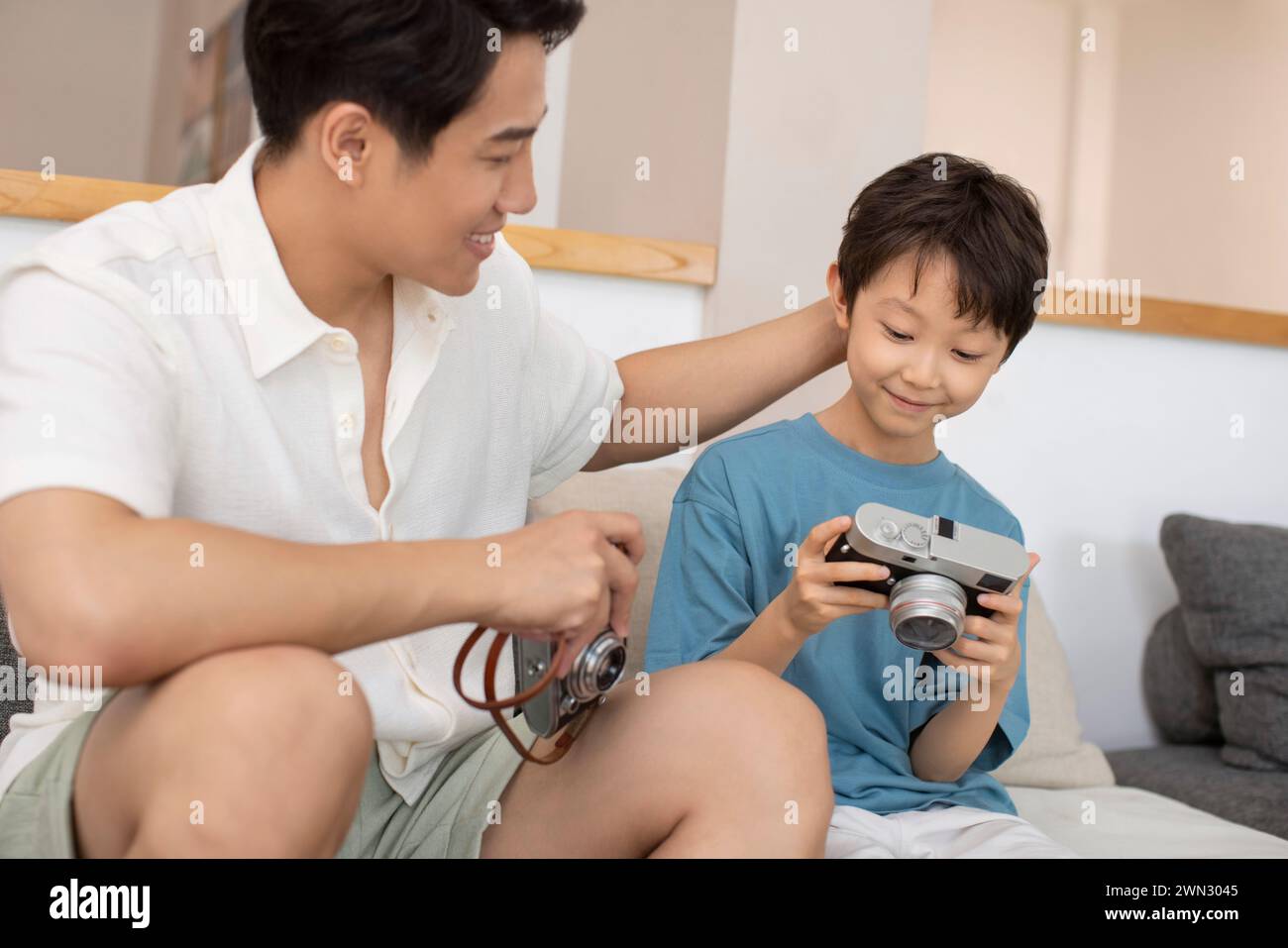 Happy father and son with cameras Stock Photo - Alamy