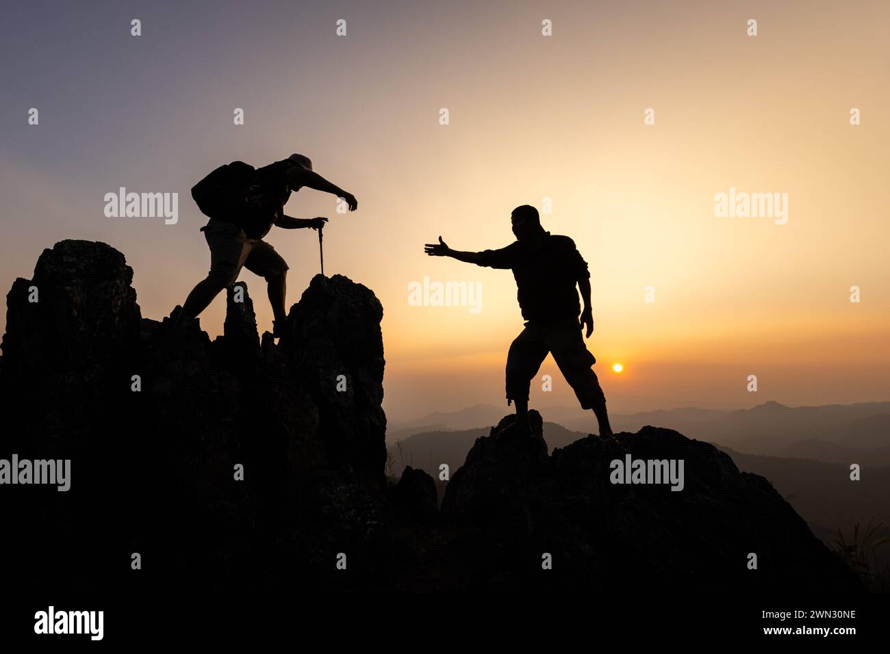 Silhouette of The men helping pull people up from high cliffs Stock ...