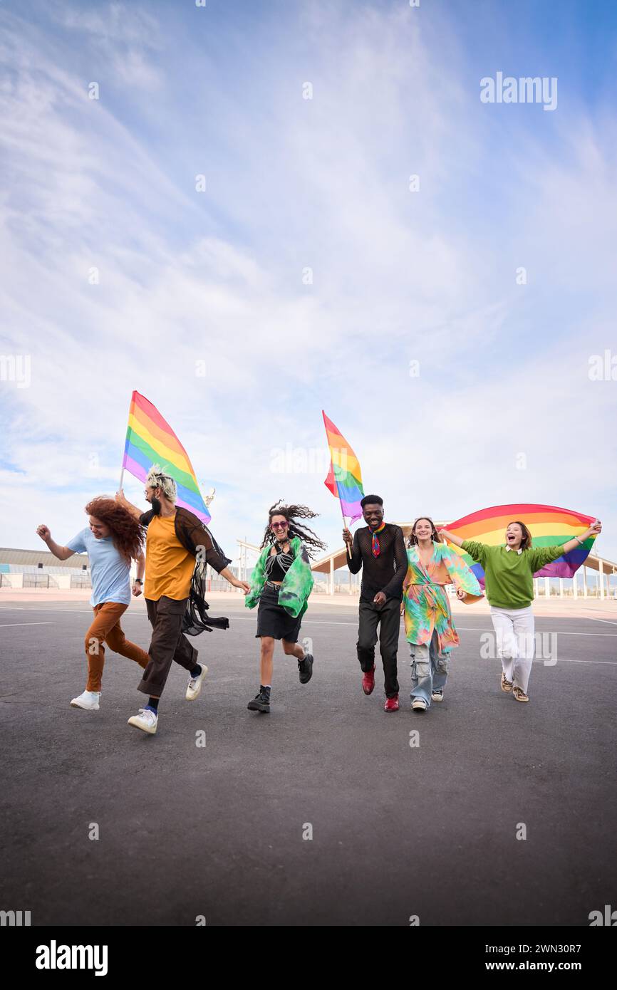 Group happy LGBT people walking down street with rainbow flags under ...