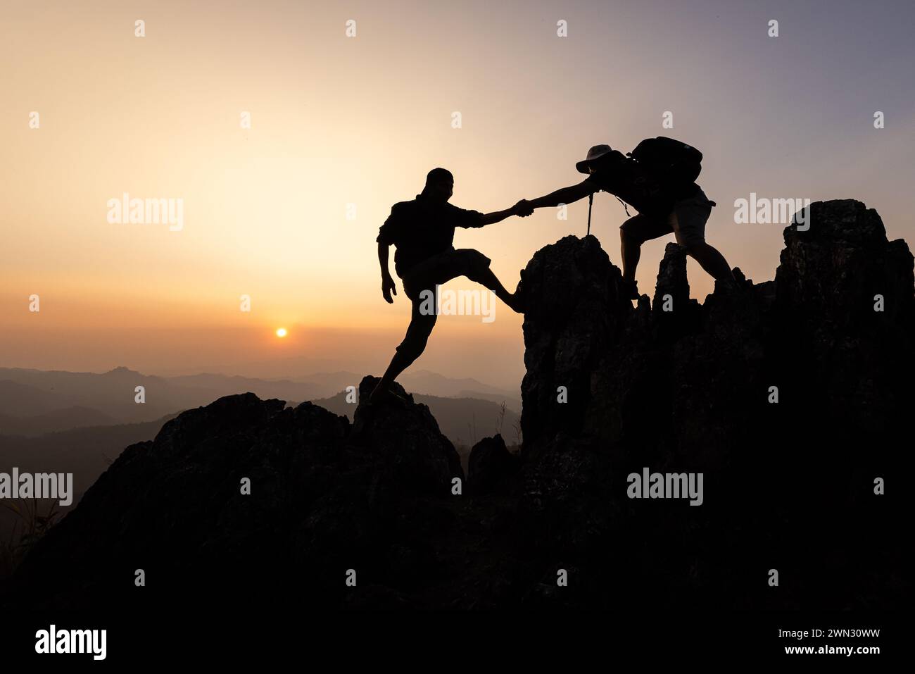 person on top of mountain. silhouette of people team hiking to top of ...