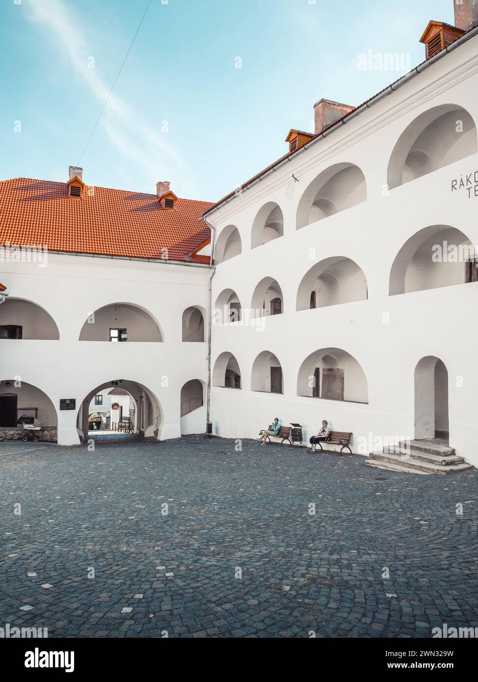 interior courtyard of Palanok Castle on a sunny day. Cobbled inner yard ...