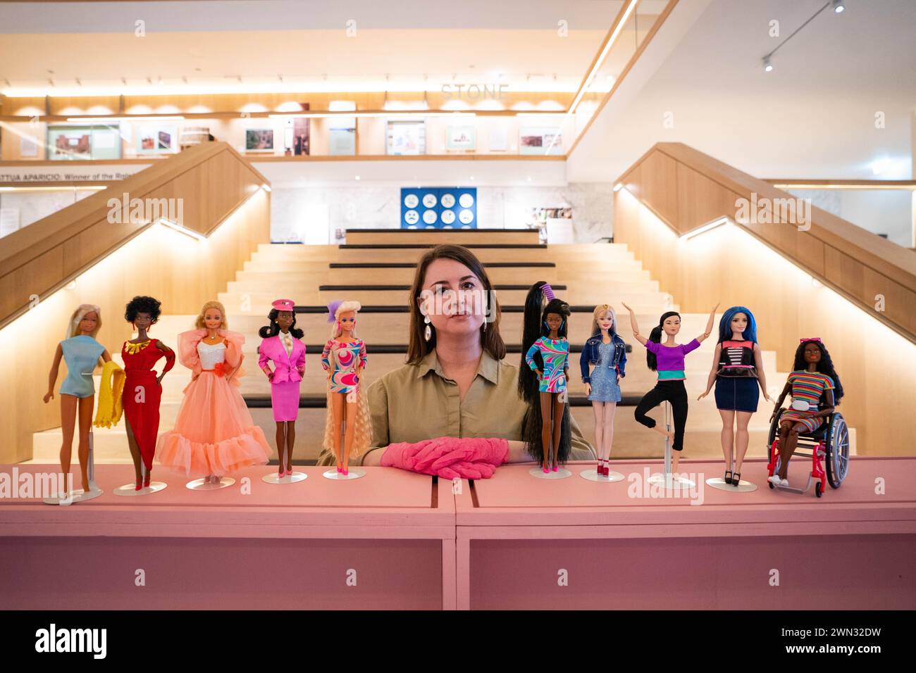 Exhibition curator Danielle Thom stands among Barbie dolls ahead of ...
