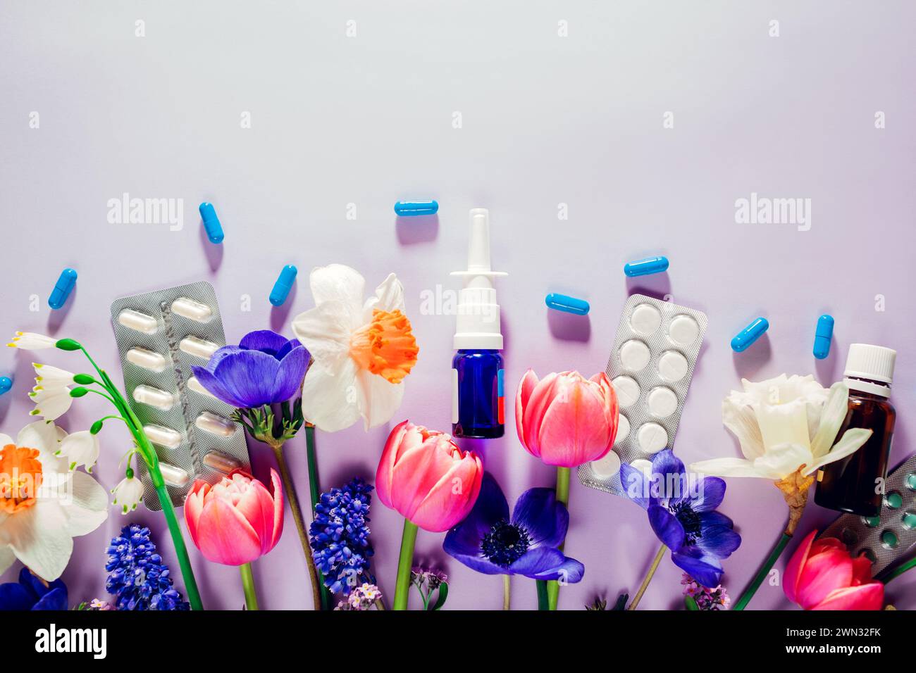 Seasonal spring allergy. Pills and nasal spray flat lay with purple ...