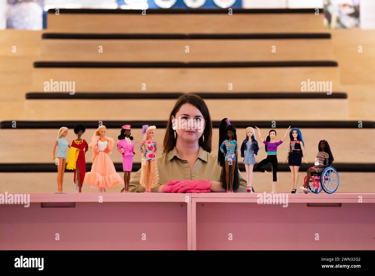 Exhibition curator Danielle Thom stands among Barbie dolls ahead of ...