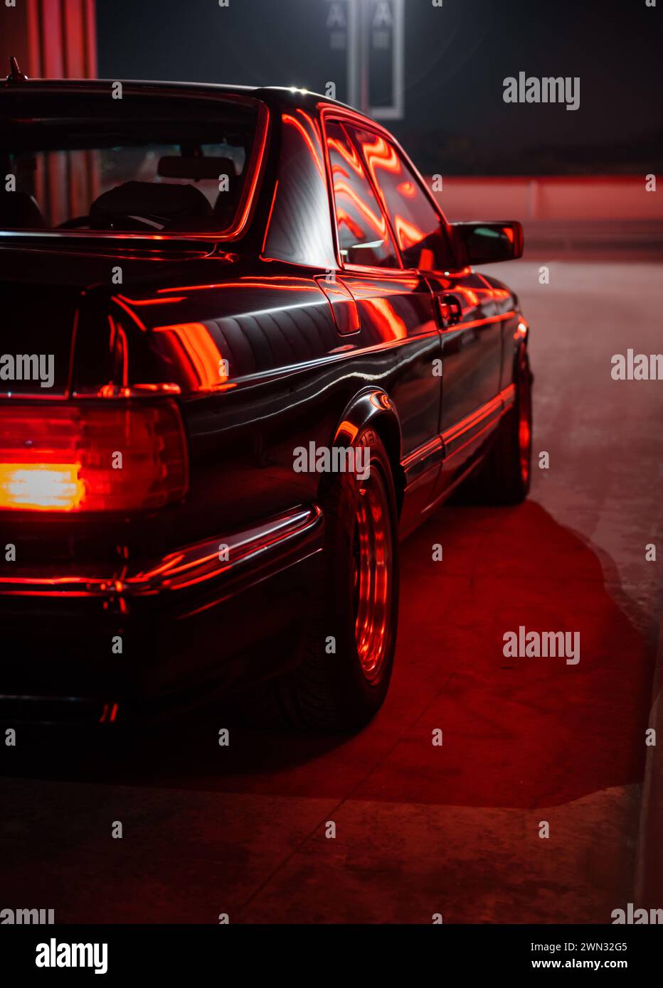 black Mercedes Benz SEC coupe at night near the neon wall. Rear right ...