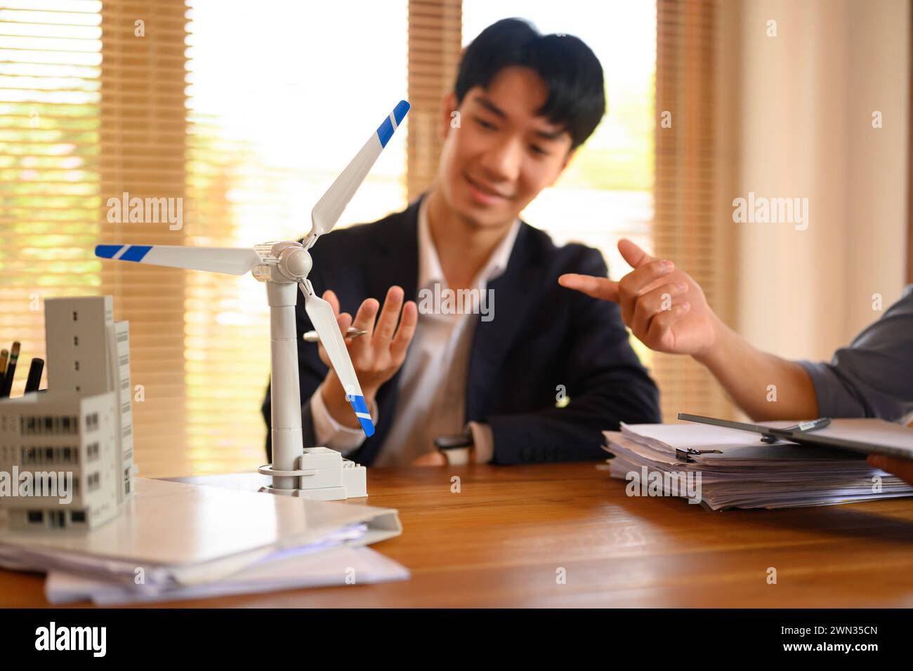 Engineer man explaining wind turbine models to colleagues working on ...