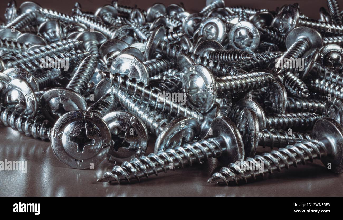 A bunch of metal screws on a black background. Metal screws background ...