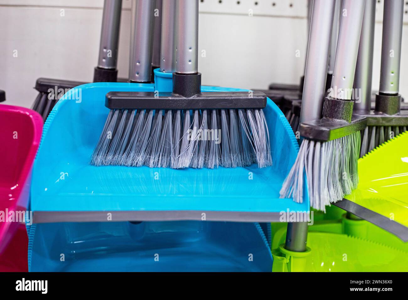 multi-colored dustpan and broom sets for cleaning in a supermarket ...