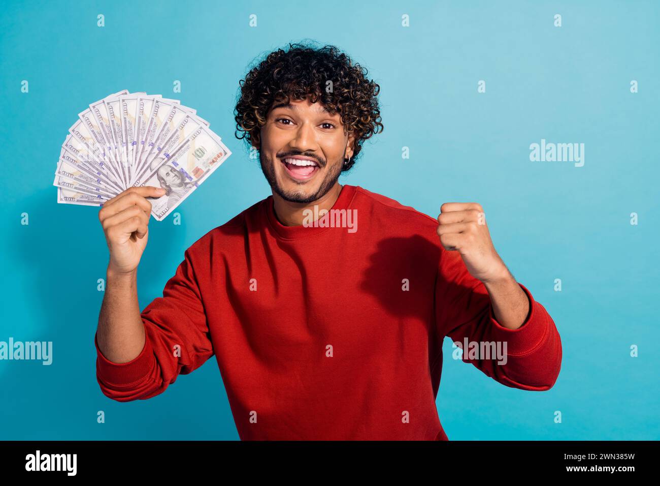 Photo of young overjoyed mexican guy in red pullover raised fist up ...