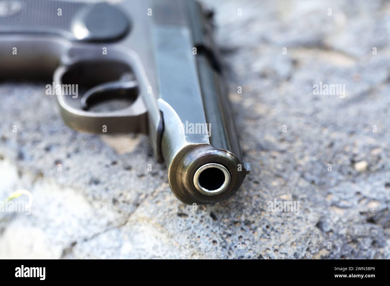 Handgun closeup on gray stone background Stock Photo - Alamy
