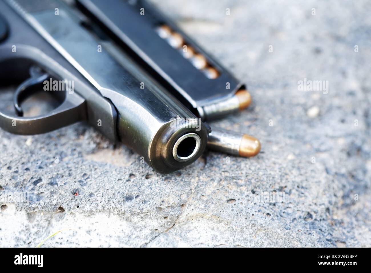 Handgun cartridge near pistol closeup on gray stone background Stock ...
