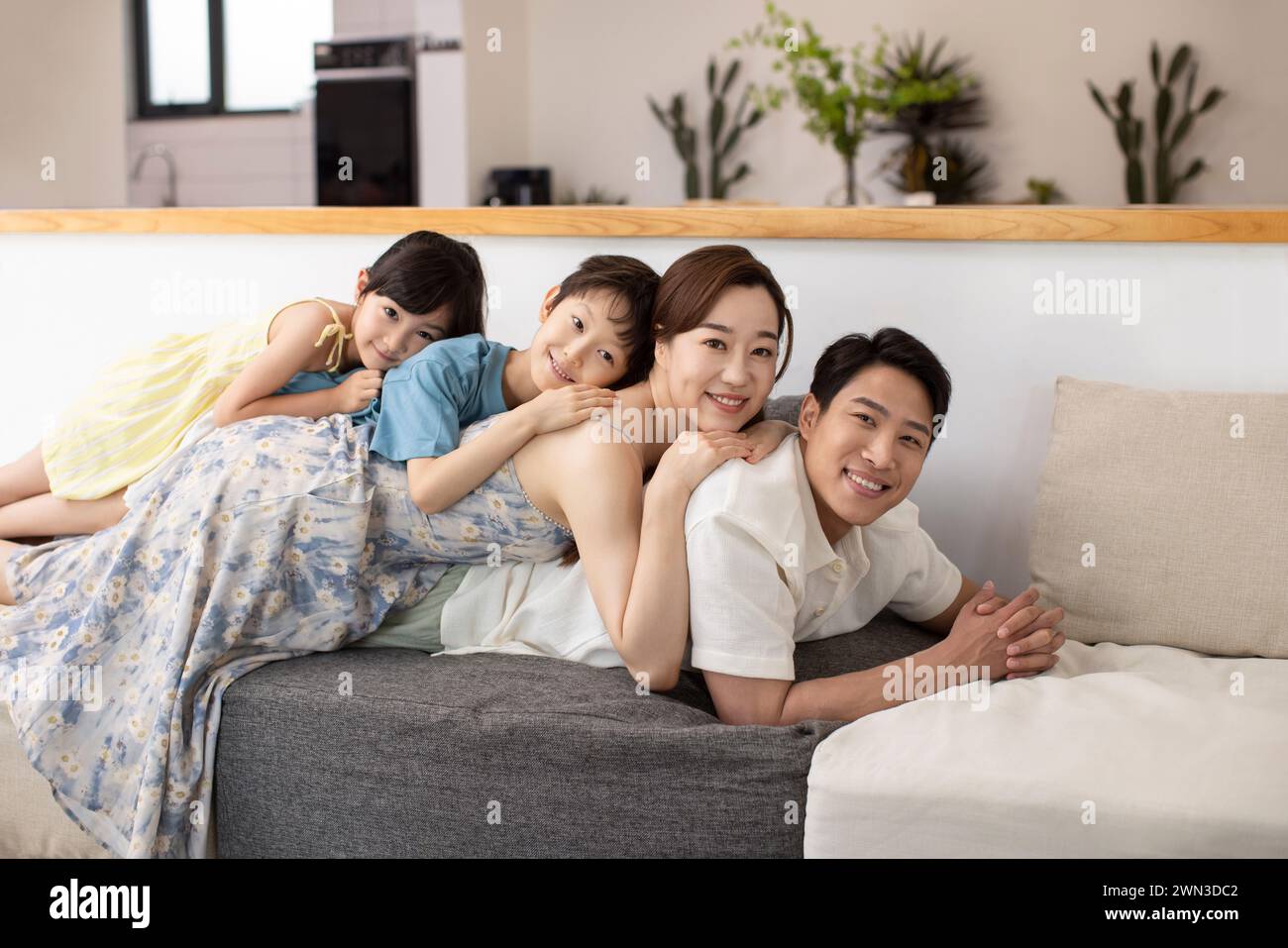 Happy family relaxing on sofa Stock Photo - Alamy