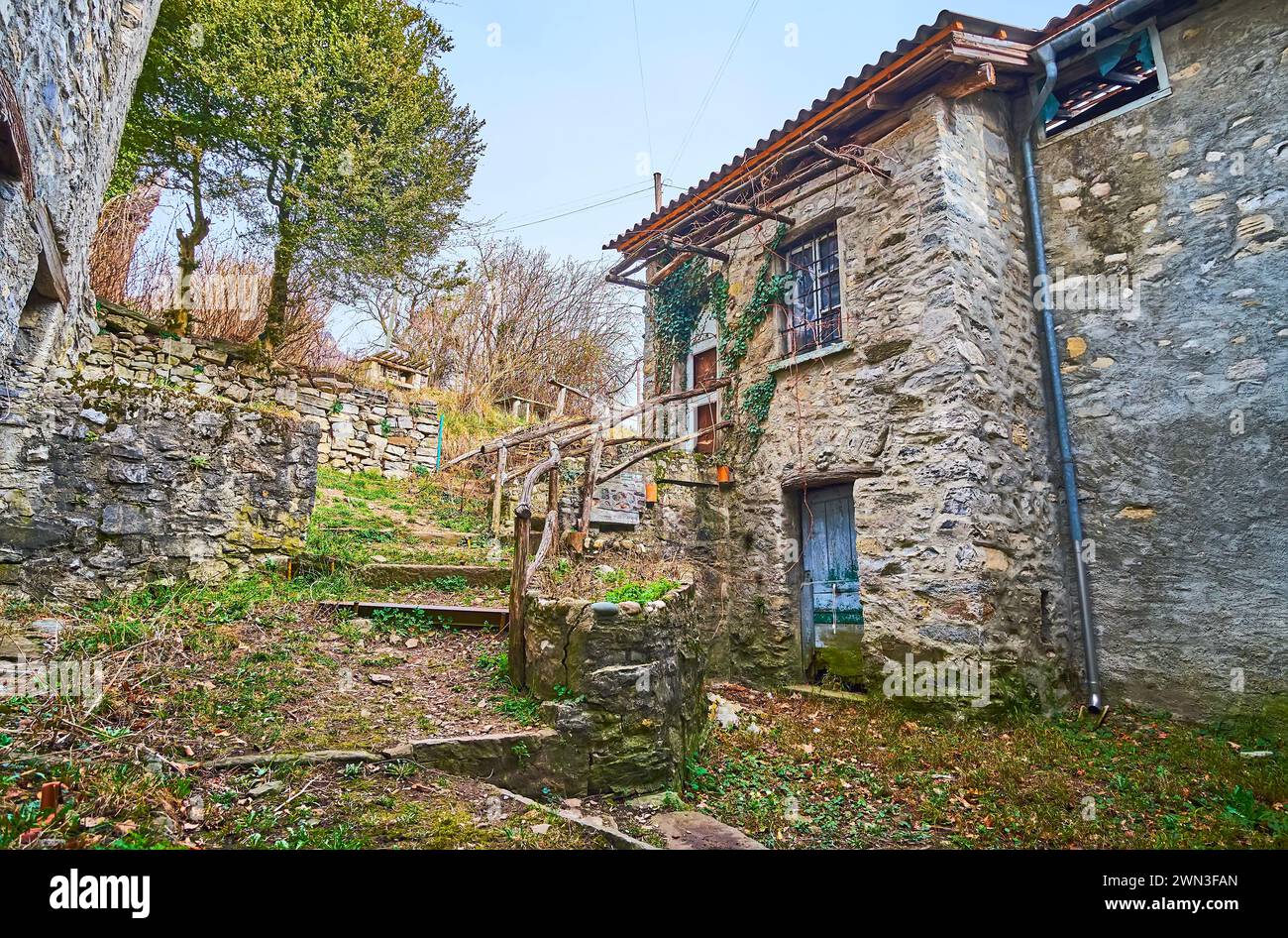 The medieval stone house and the small abandoned garden on the slope ...