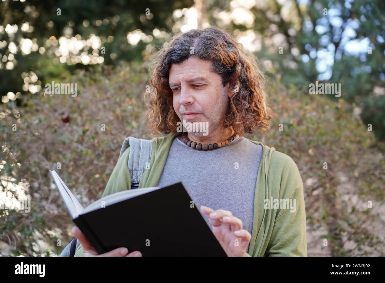 Man curly hair reading book hi-res stock photography and images - Alamy