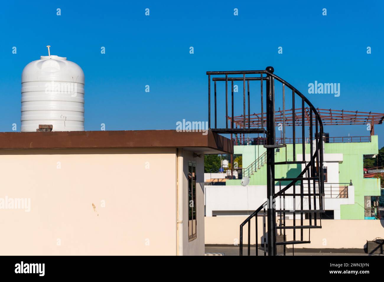 Urban Living: Rooftop View of Overhead Water Tank and Metal Staircase ...