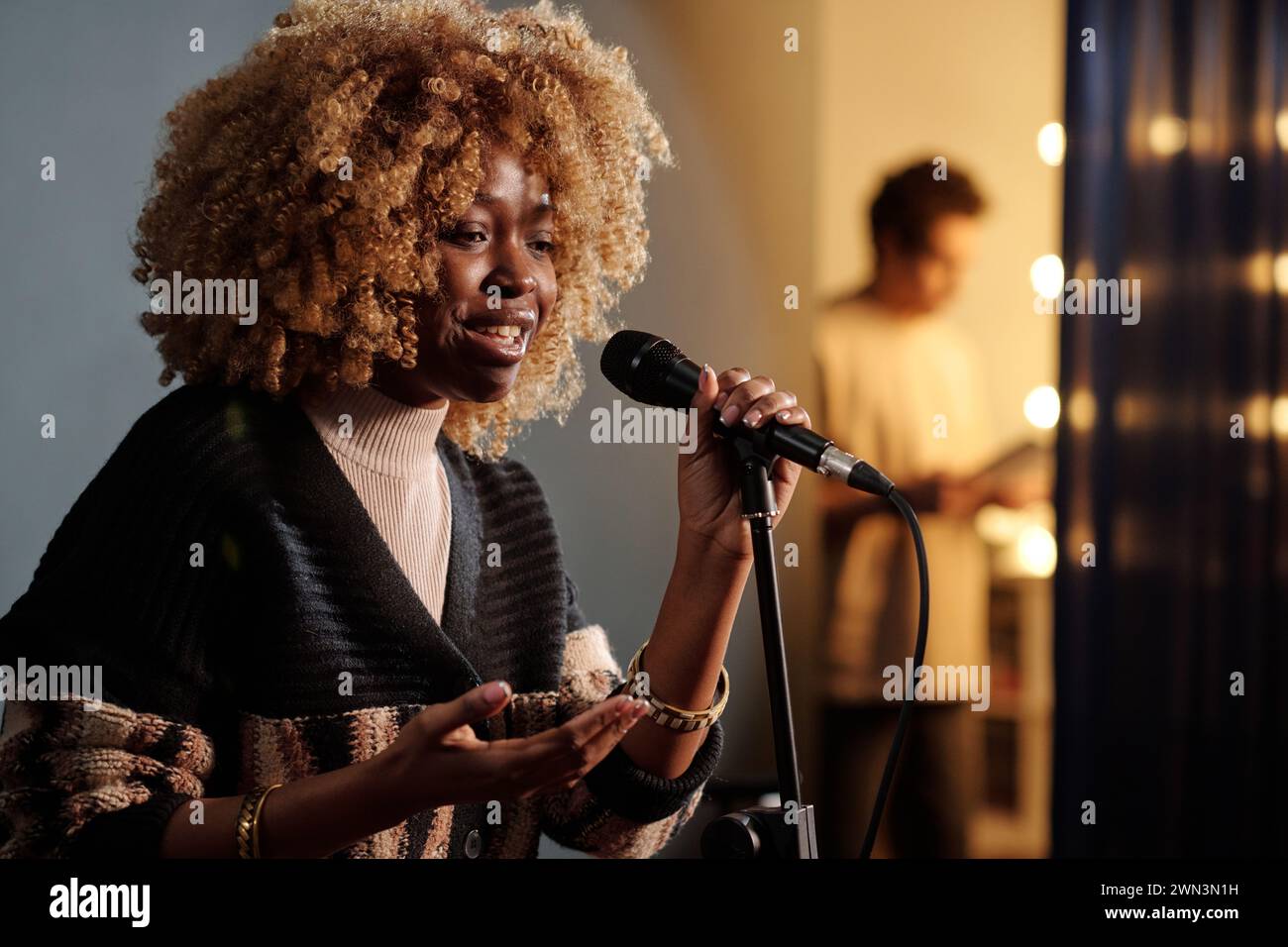 Young female stand up comedian standing on stage in front of audience ...