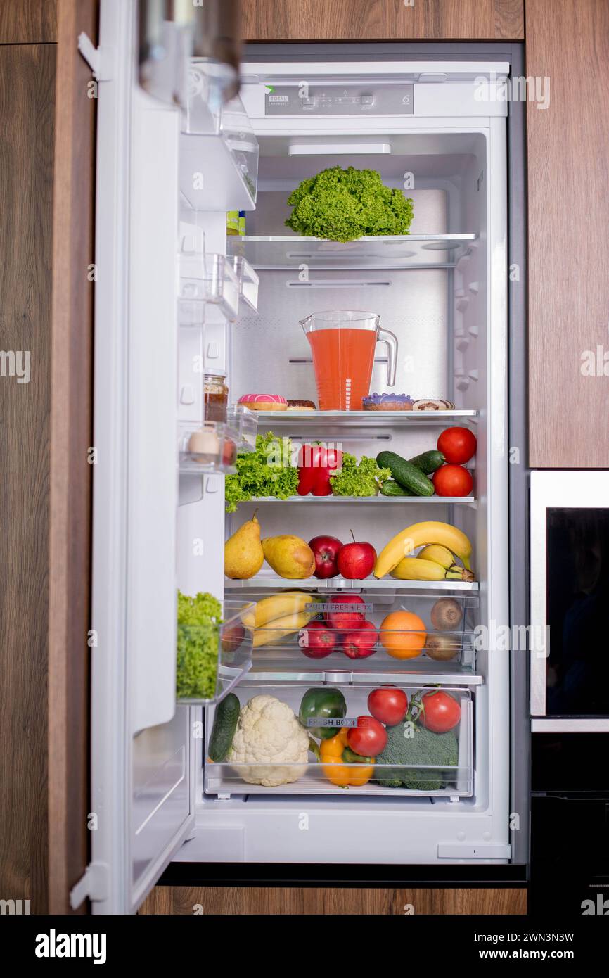 Open luxury refrigerator filled with lots of different types of food ...