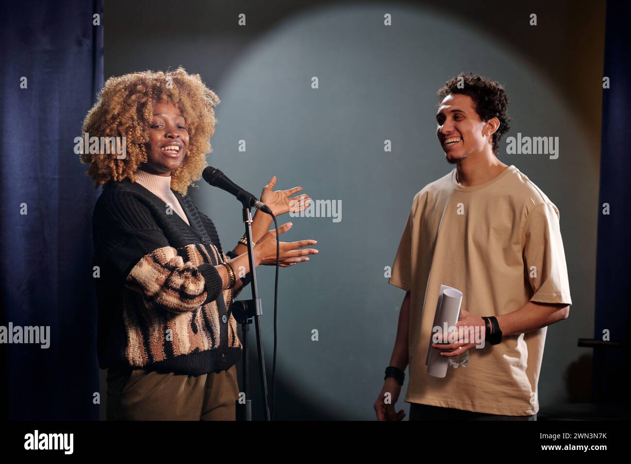 Young cheerful African American woman presenting audience new male ...