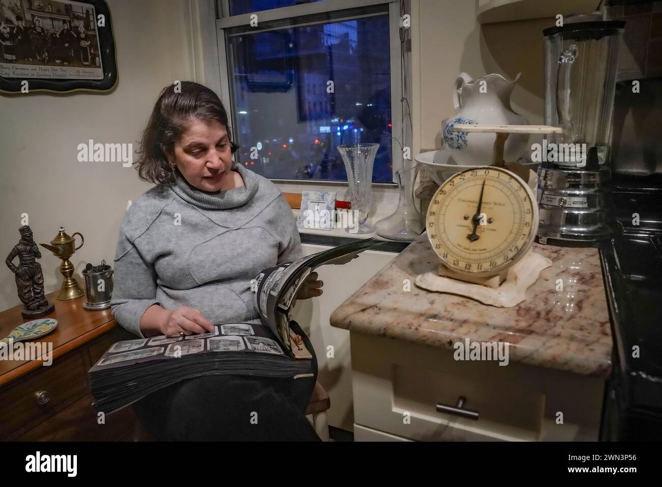 Anne D'Innocenzio scrolls through a family album inside her kitchen ...