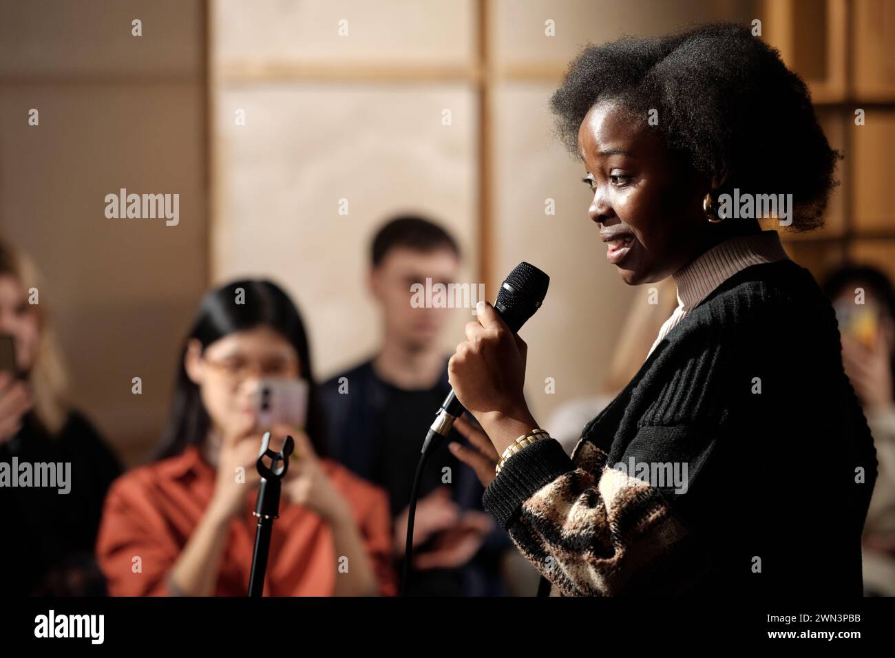 Side view of female comedian of modern stand up club pronouncing ...