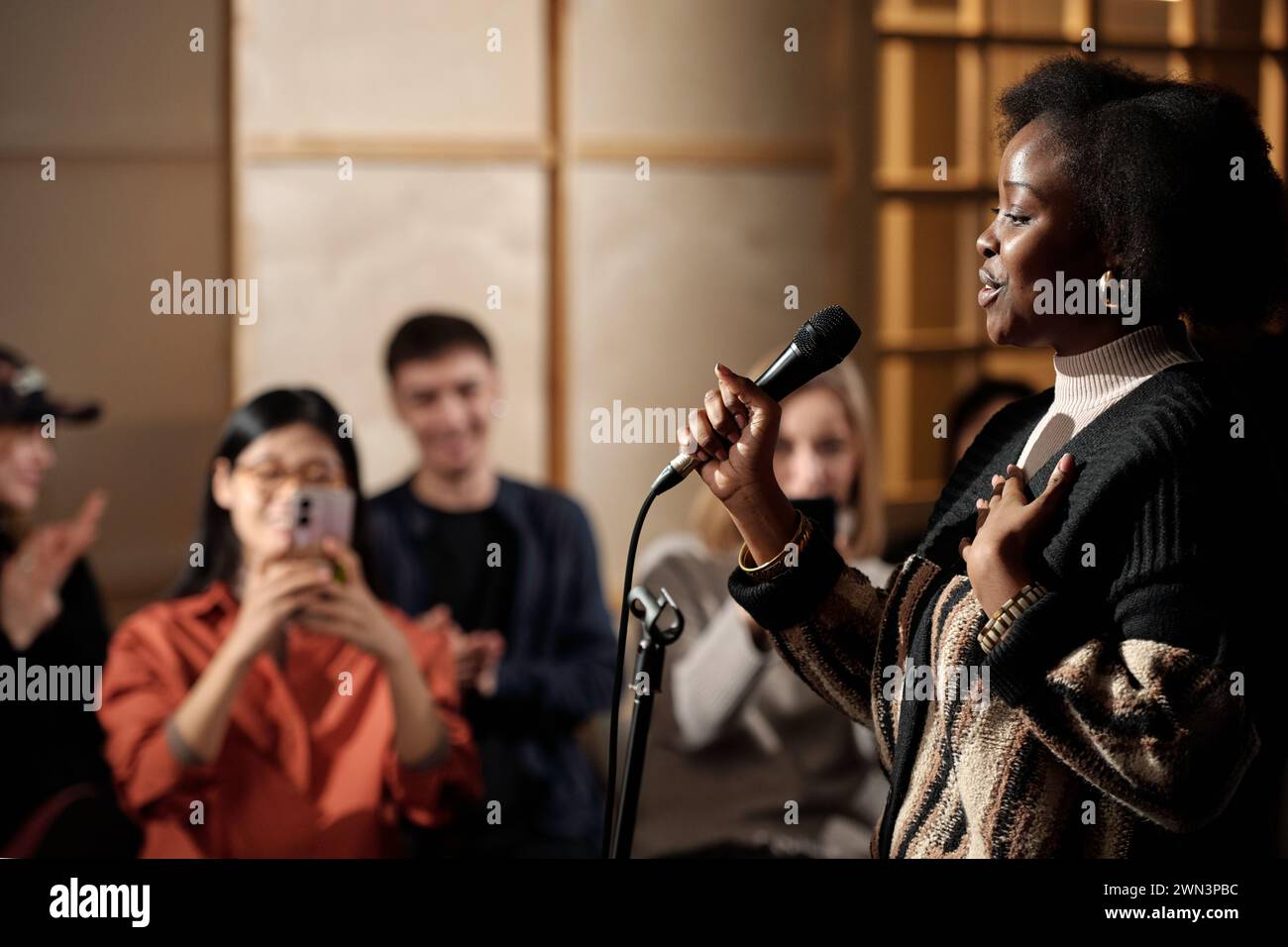 Young African American female presenter with microphone standing in ...
