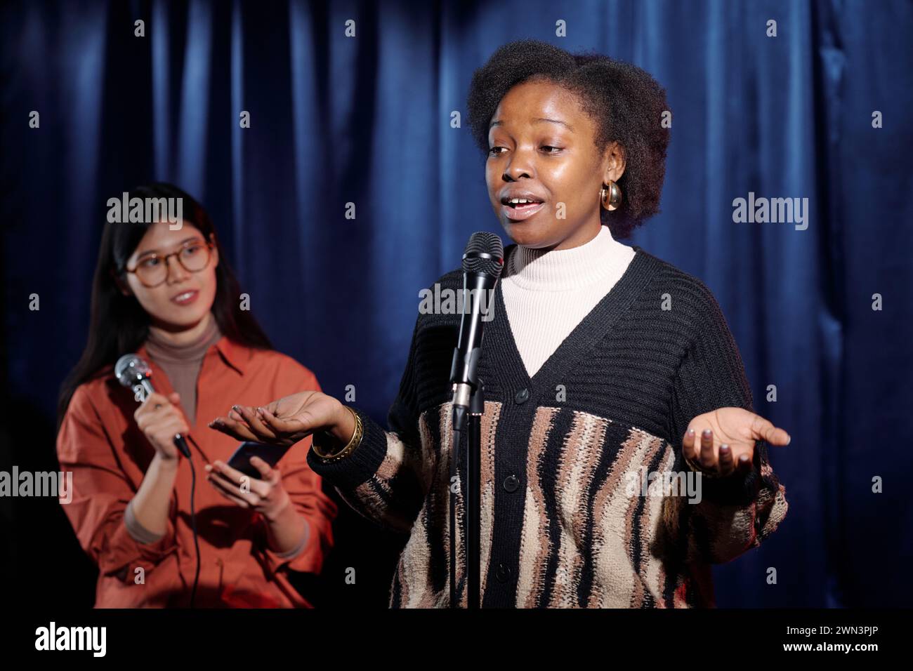 Young female comedian of stand up show pronouncing monologue while ...