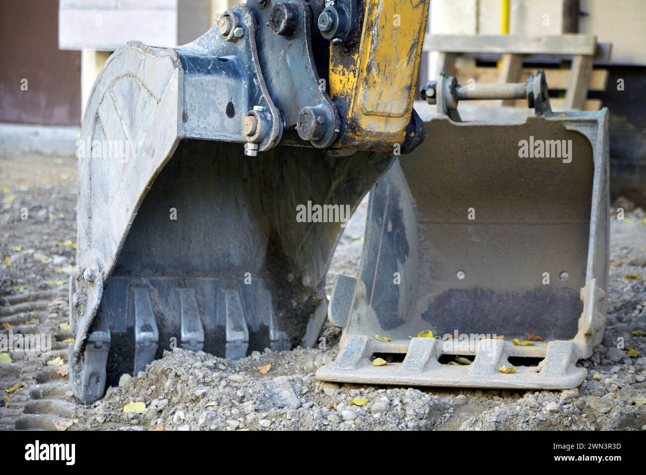 Two excavator buckets at the construction site of road repair work ...