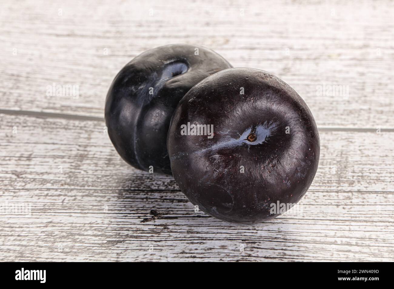 Two ripe sweet black plums isolated Stock Photo - Alamy