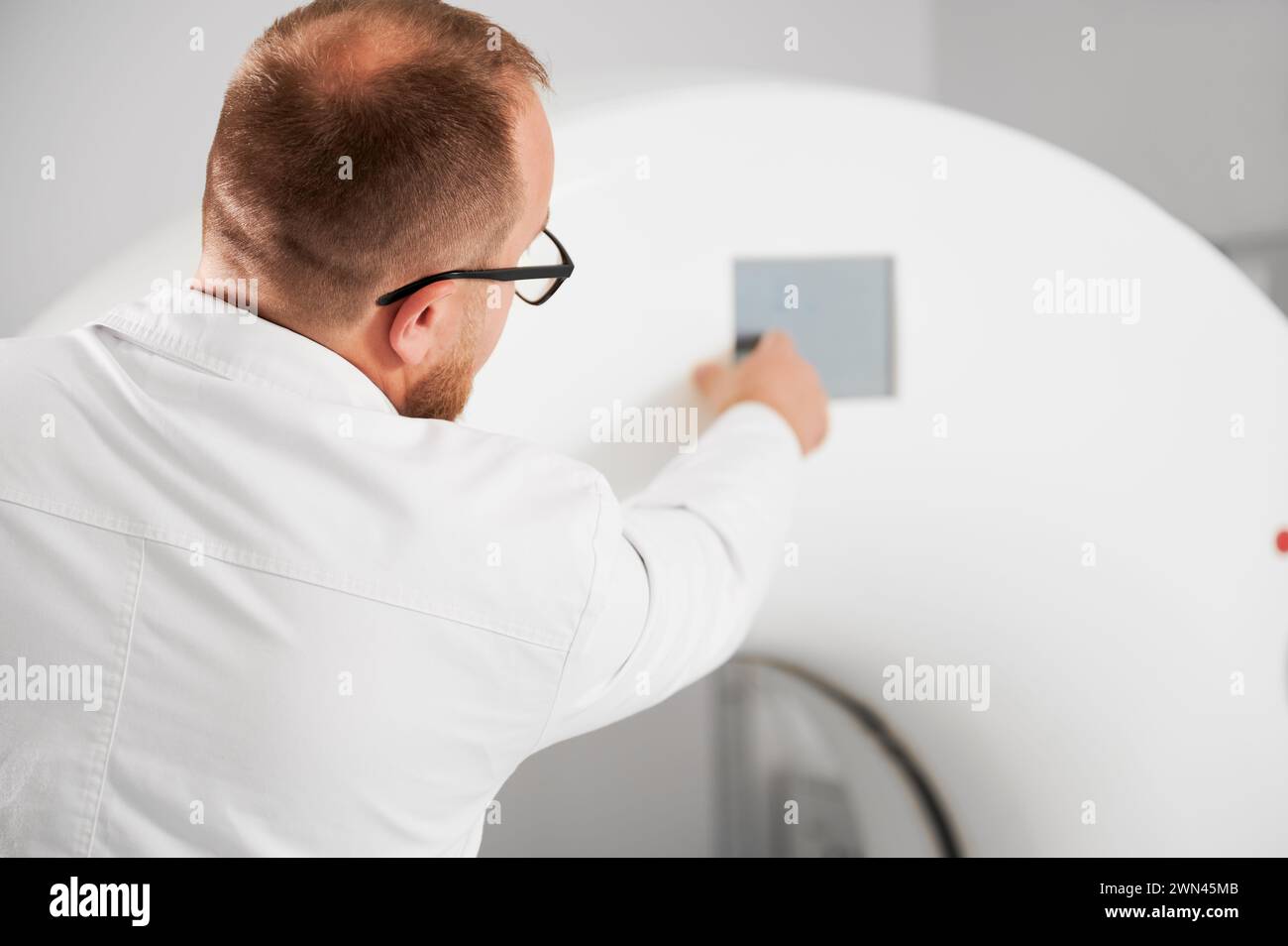 Medical computed tomography or MRI scanner. Back view of male ...