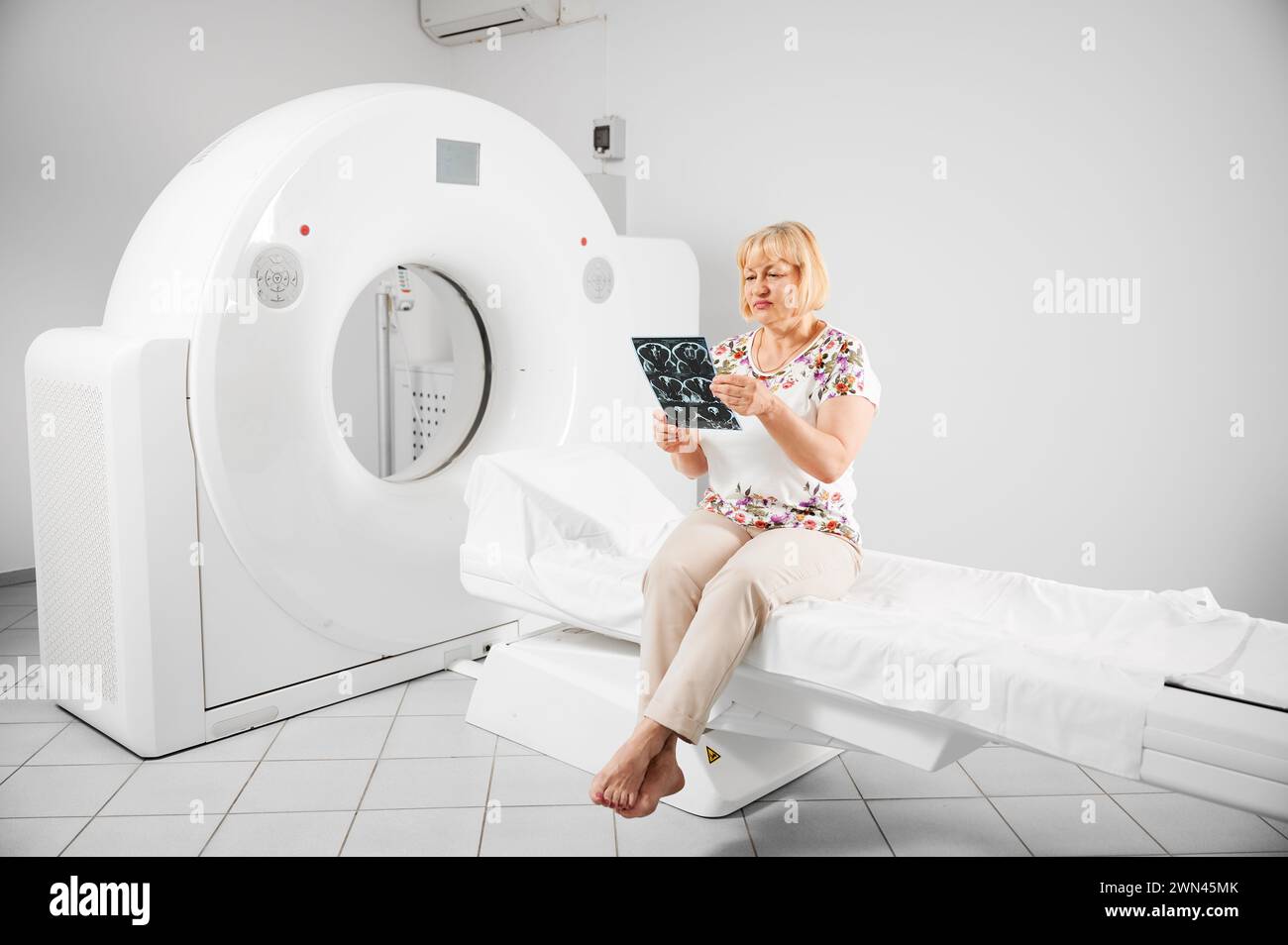Medical computed tomography or MRI scanner. Patient making MRI, sitting ...