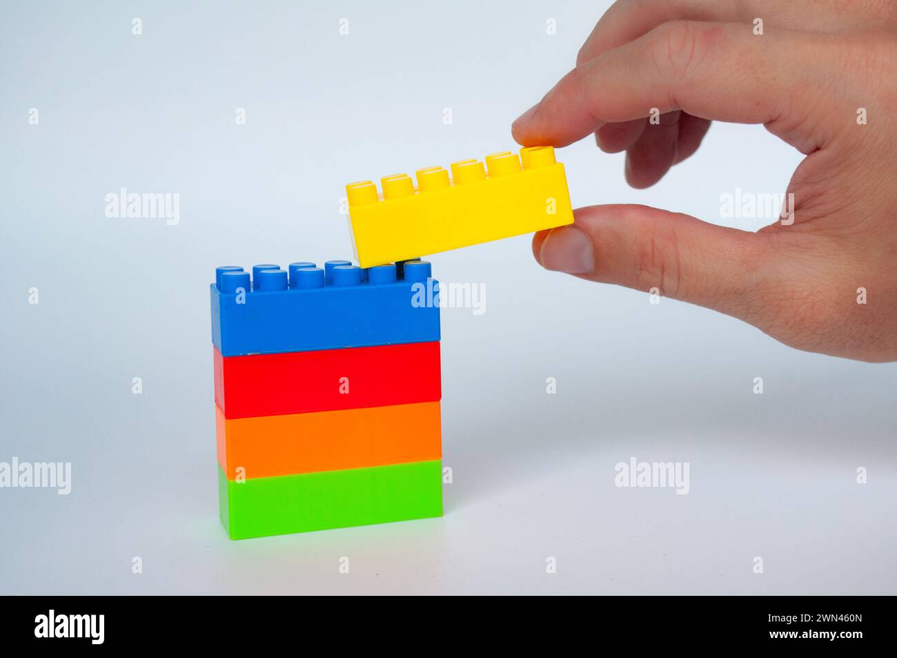 Hand stacking up lego set. Building concept Stock Photo - Alamy