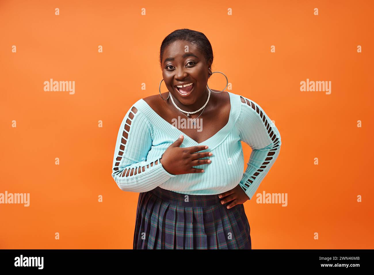 amazed plus size african american woman in blue long sleeve laughing ...