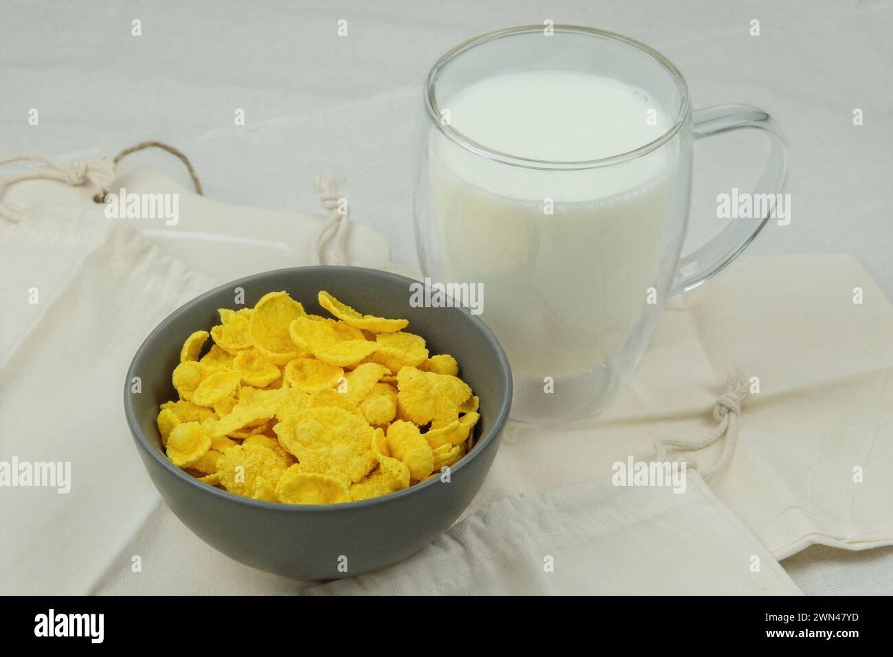 Breakfast cereals. Cornflakes in bowls and cup of milk on a light ...