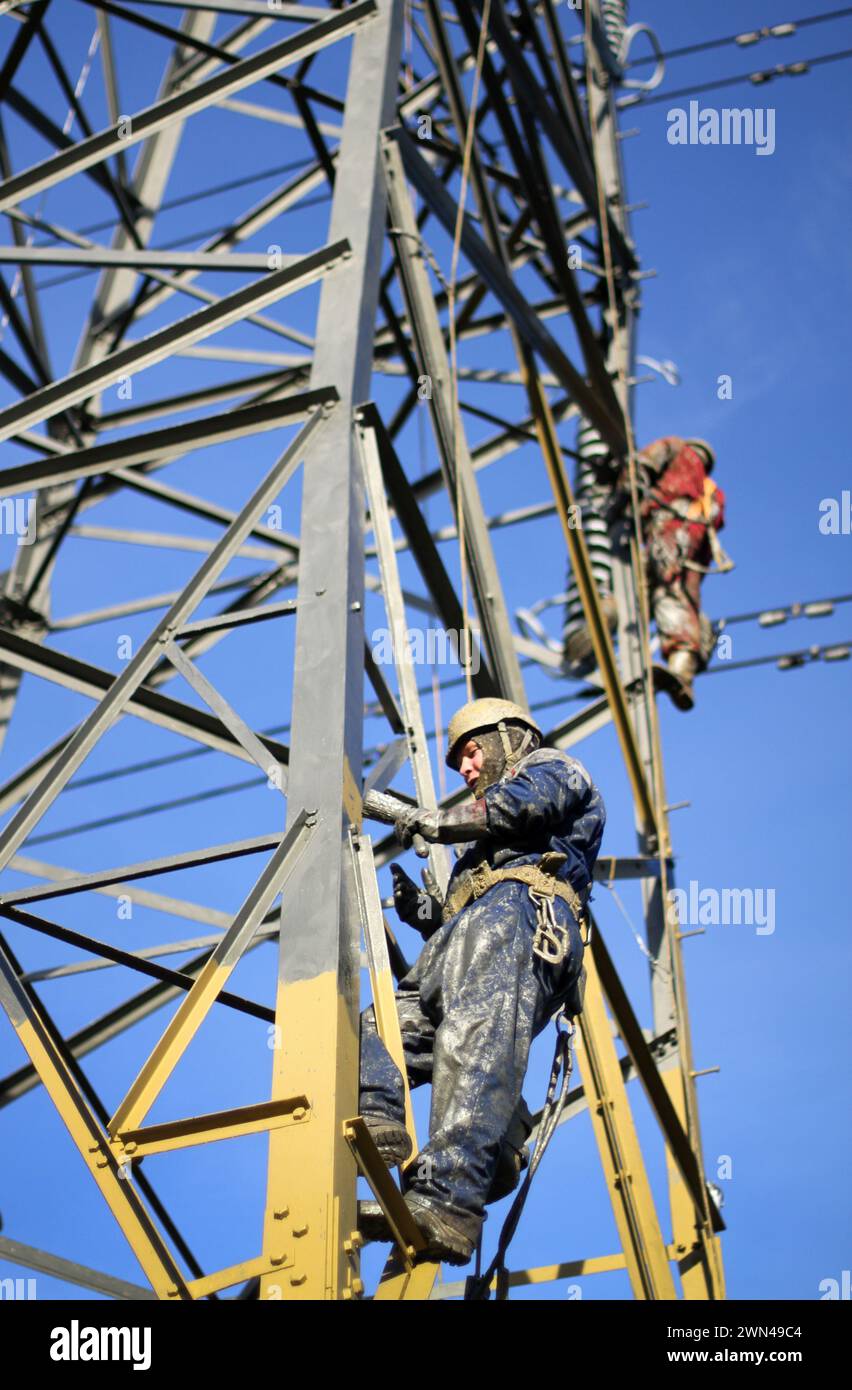 29/11/12 Workmen paint high voltage electricity pylons near Alderley ...