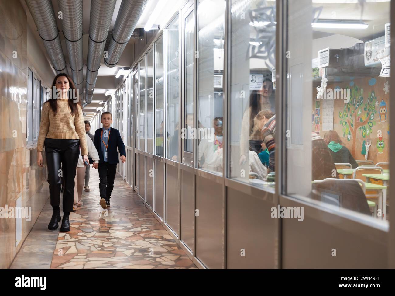 A young female teacher leads children to their class. Ukrainian ...