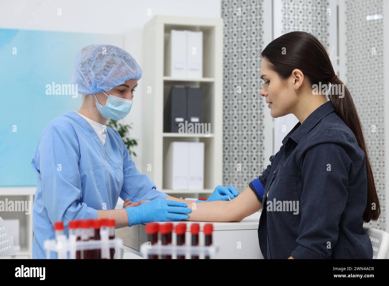 Laboratory testing. Doctor taking blood sample from patient at table in ...