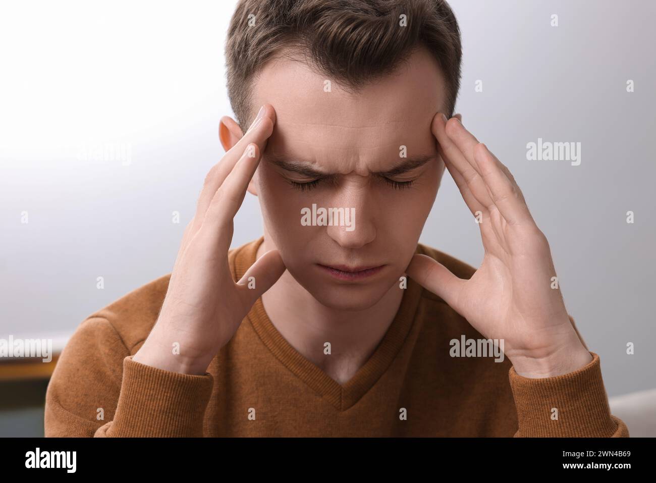 Sad man suffering from headache at home Stock Photo - Alamy