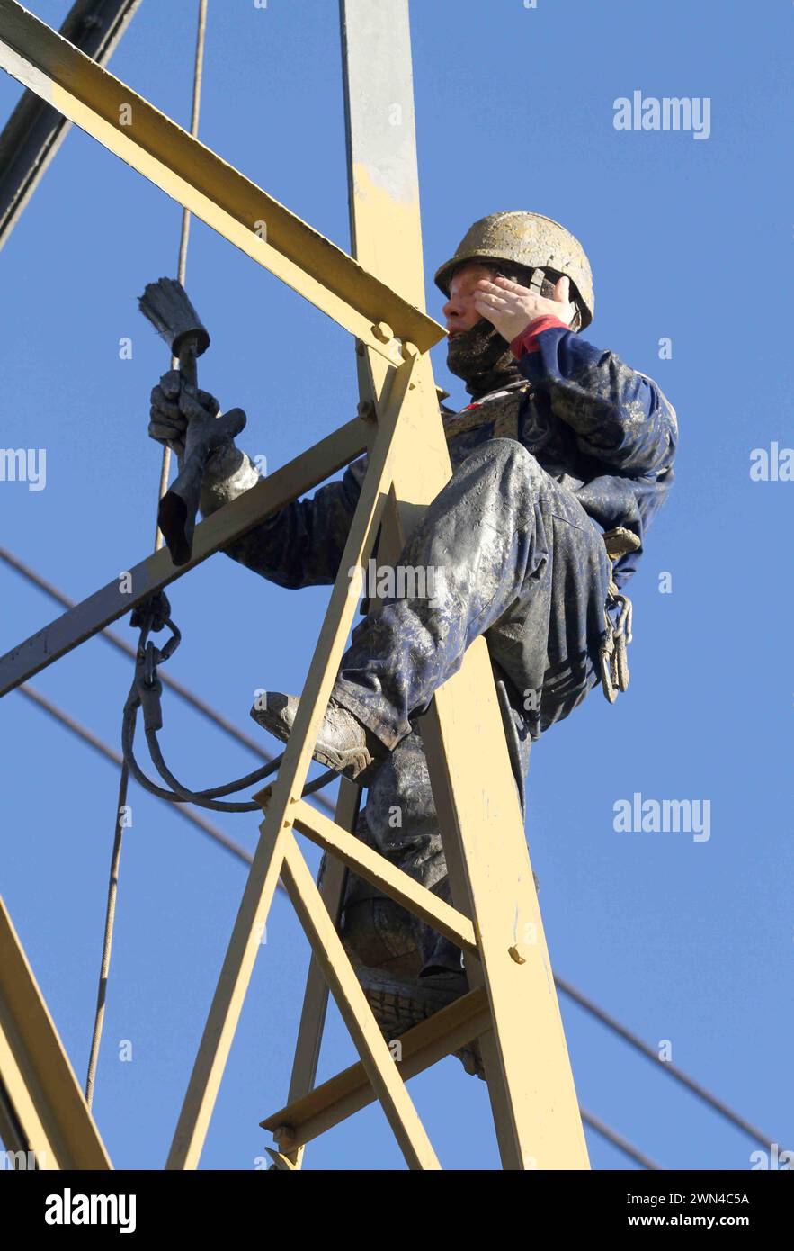 29/11/12 Workmen paint high voltage electricity pylons near Alderley ...