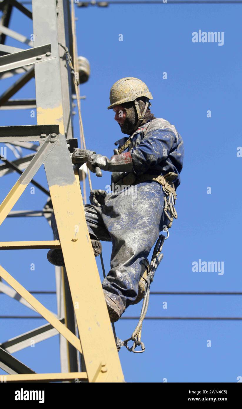 29/11/12 Workmen paint high voltage electricity pylons near Alderley ...