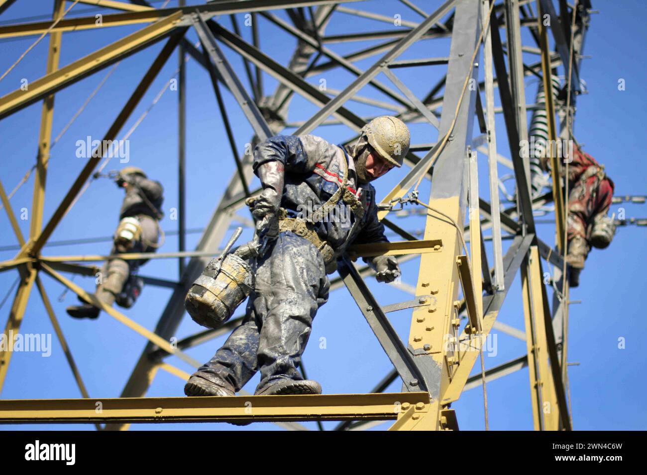 29/11/12 Workmen paint high voltage electricity pylons near Alderley ...