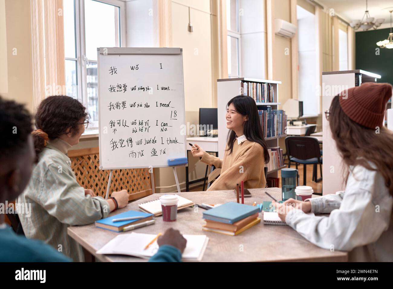 Side view of smiling Asian woman as female teacher teaching Chinese ...