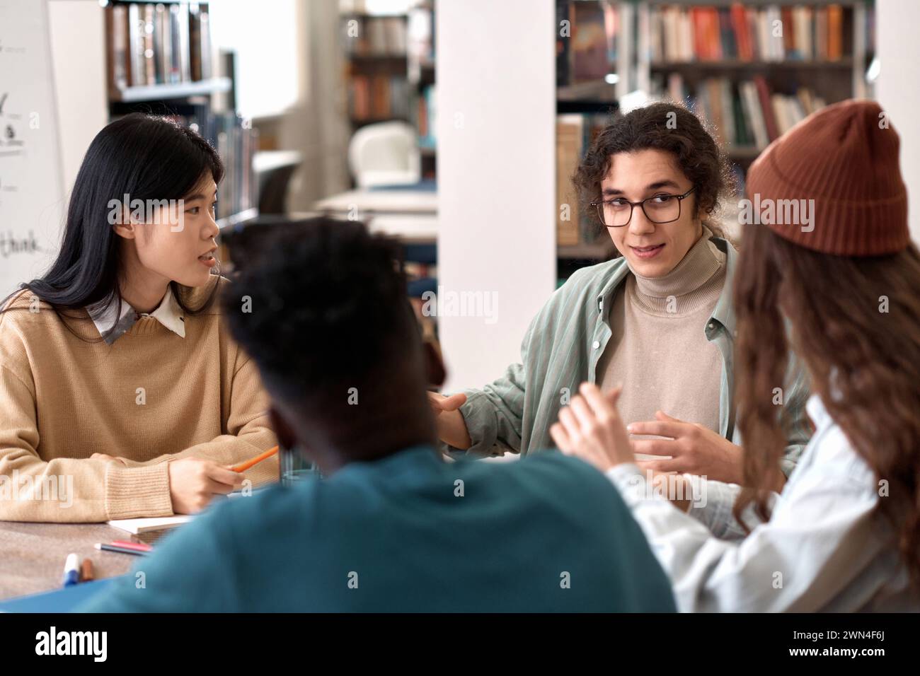 Portrait of long haired male student presenting ideas to students ...