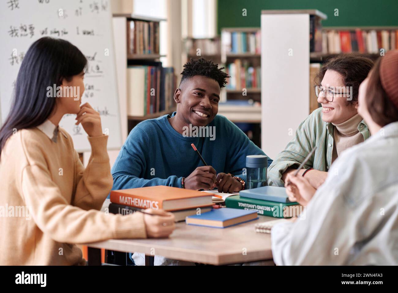 Portrait of Black young man smiling during group discussion with ...