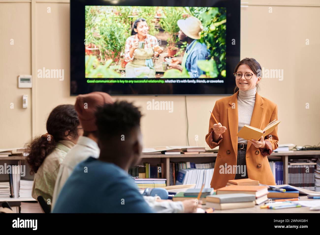 Waist up portrait of adult woman as female professor giving lecture to ...
