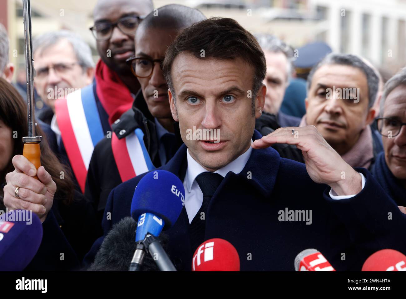France's President Emmanuel Macron, surrounded by officials, attends ...