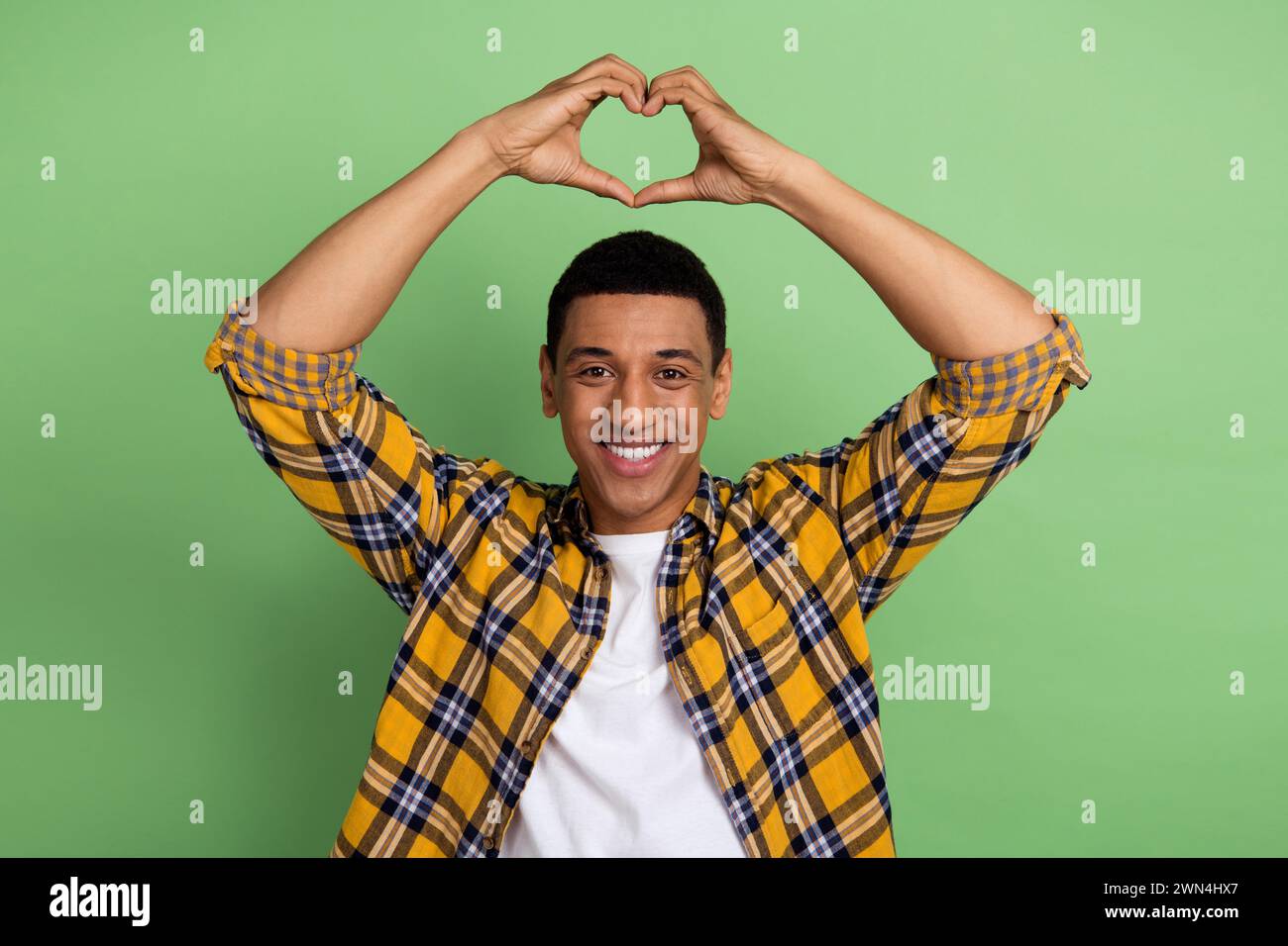 Portrait of positive young man beaming smile arms demonstrate heart ...