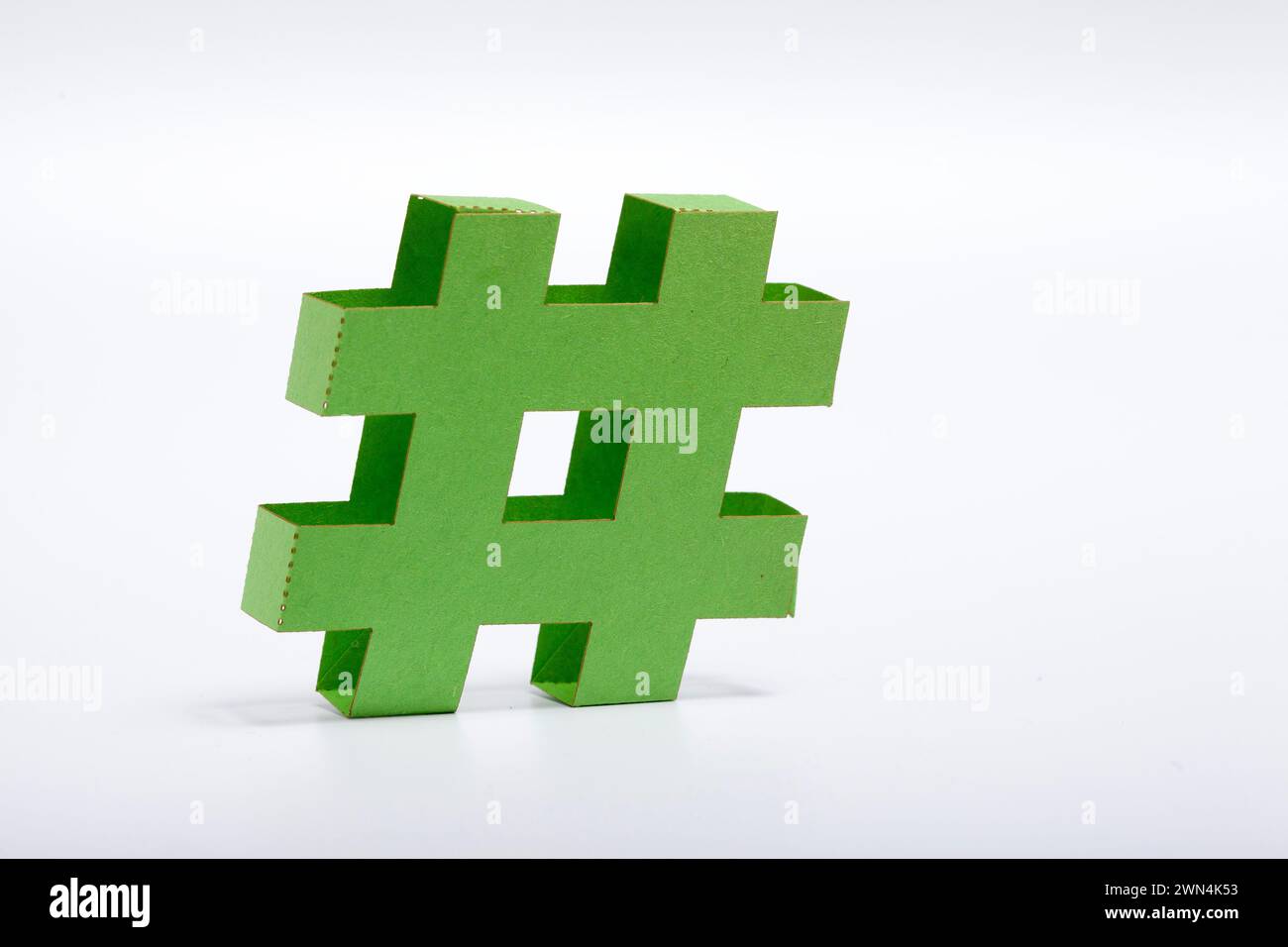 green paper hashtag symbol on white background Stock Photo - Alamy